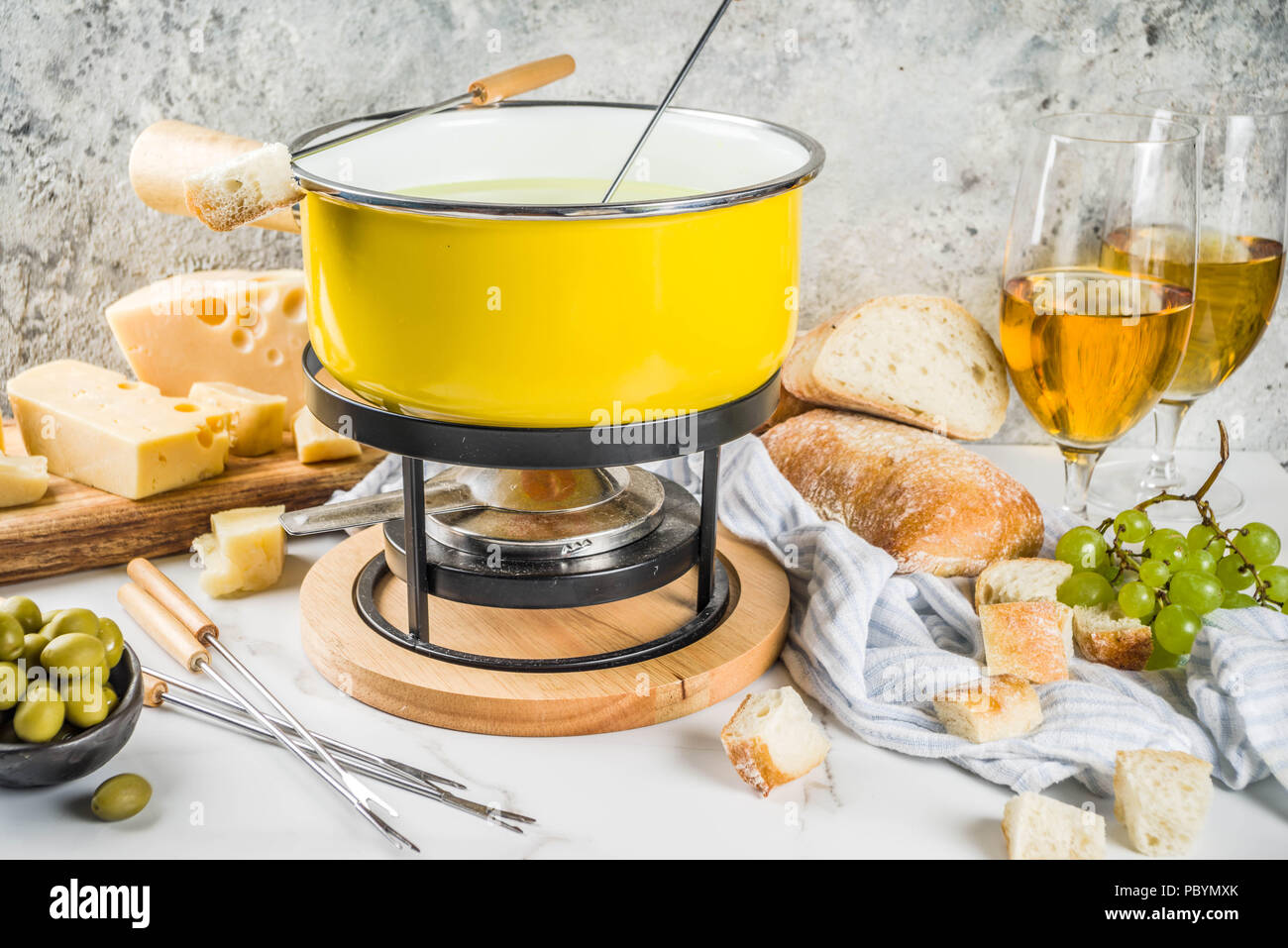 Gourmet Swiss fondue in traditional fondue pot, with forks, various ...