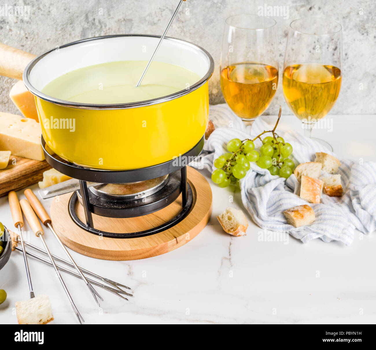Gourmet Swiss fondue in traditional fondue pot, with forks, various ...