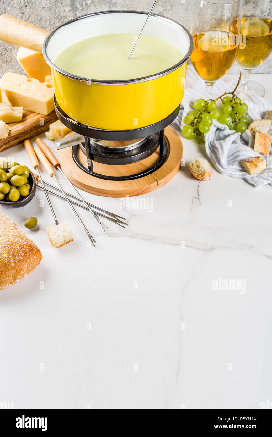 Gourmet Swiss fondue in traditional fondue pot, with forks, various ...