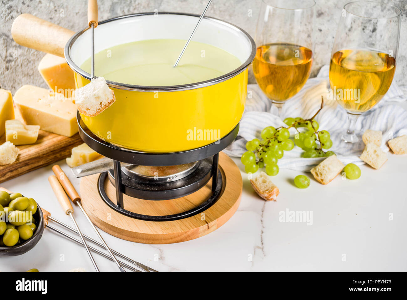 Gourmet Swiss fondue in traditional fondue pot, with forks, various ...