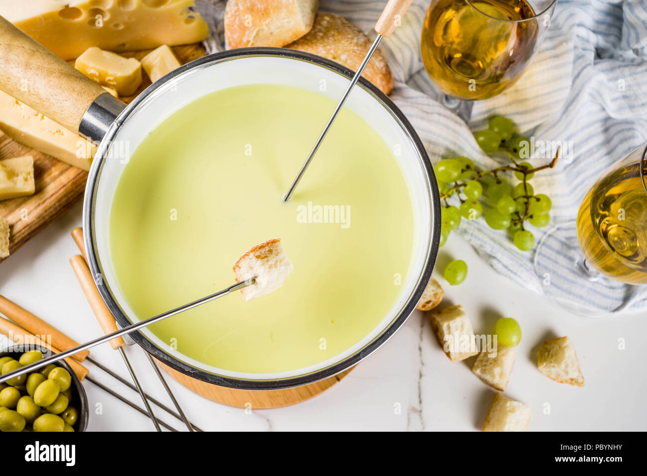 Gourmet Swiss fondue in traditional fondue pot, with forks, various ...