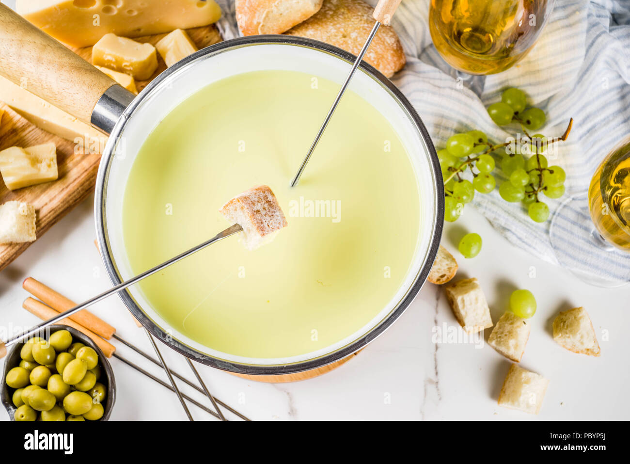 Gourmet Swiss fondue in traditional fondue pot, with forks, various ...