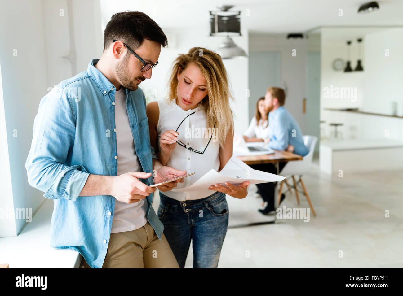 Picture of young architects discussing about project Stock Photo - Alamy
