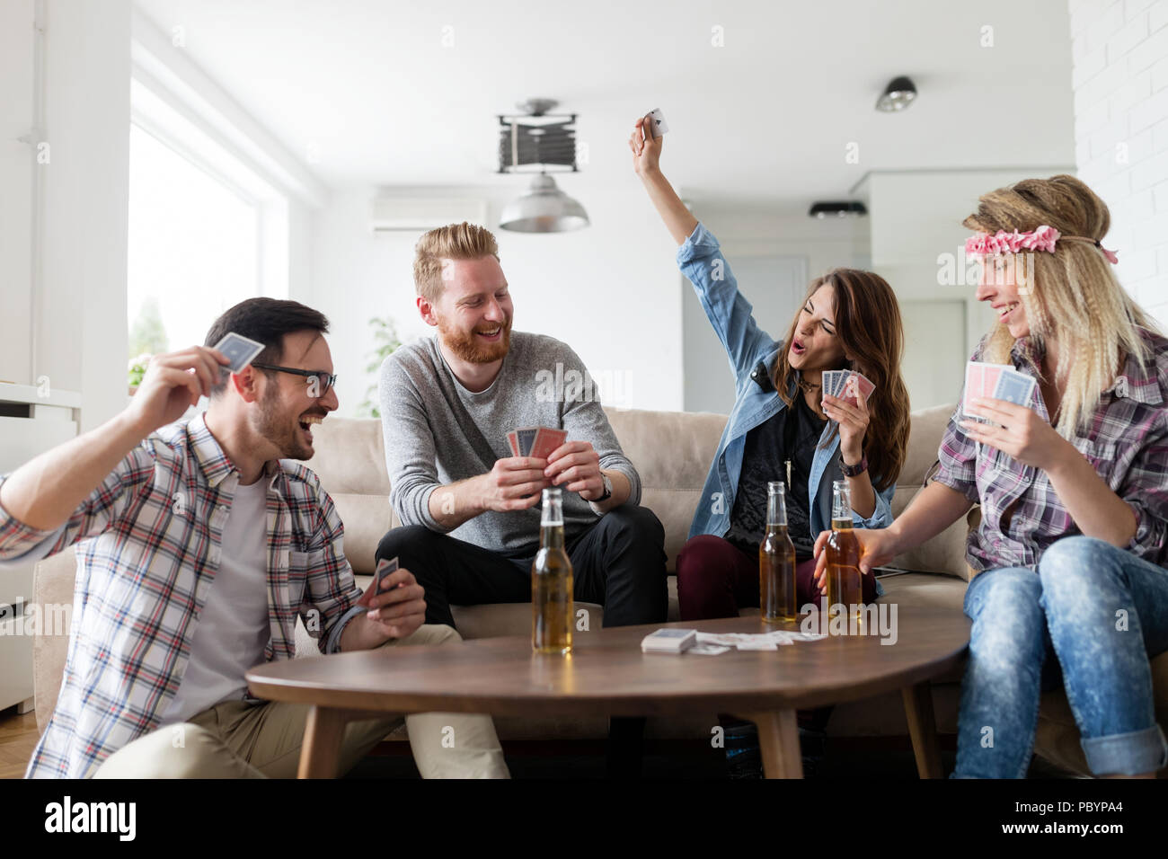 Happy group of friends playing cards and drinking Stock Photo - Alamy