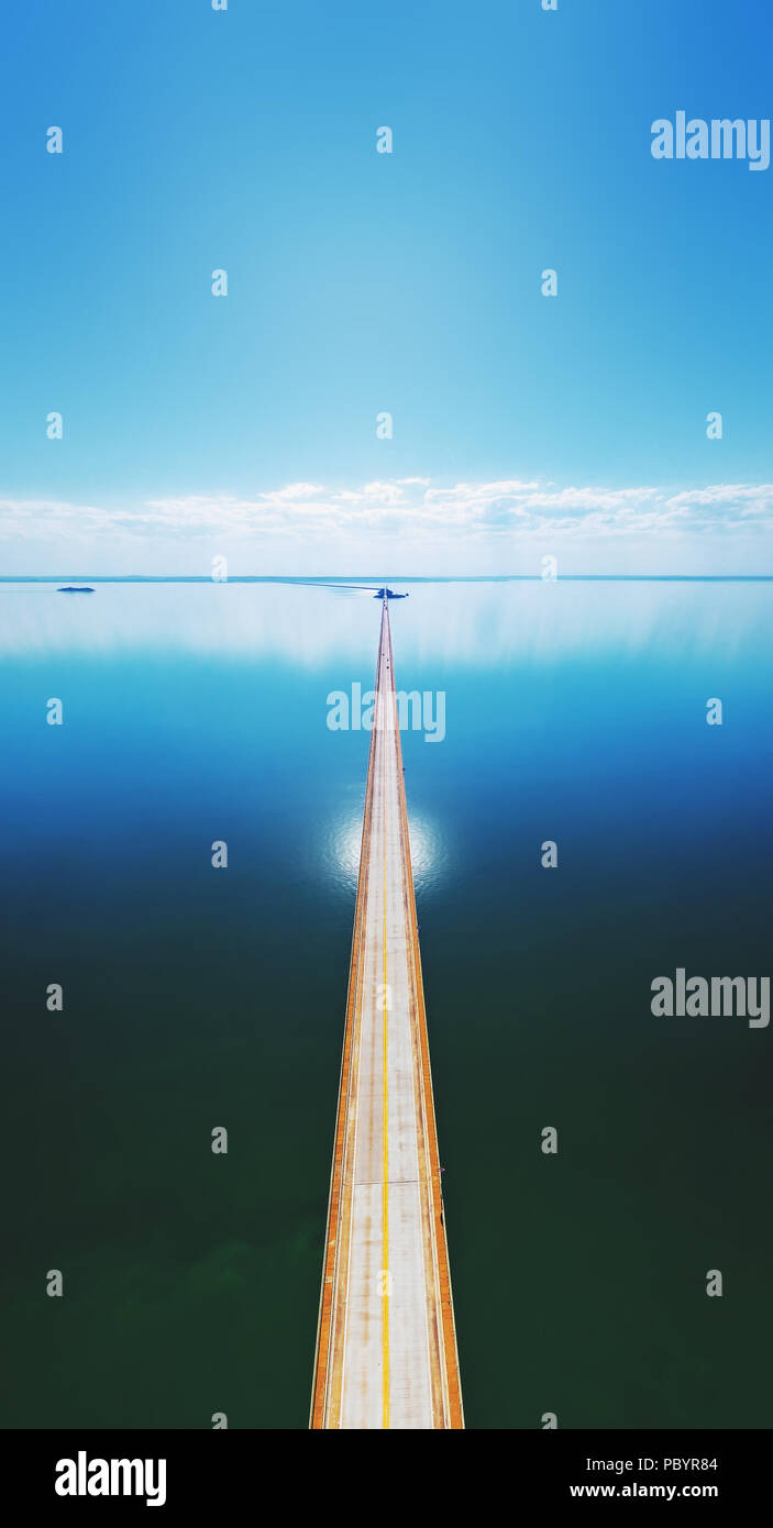 Aerial top view of a long highway bridge above a river. Vertical ...