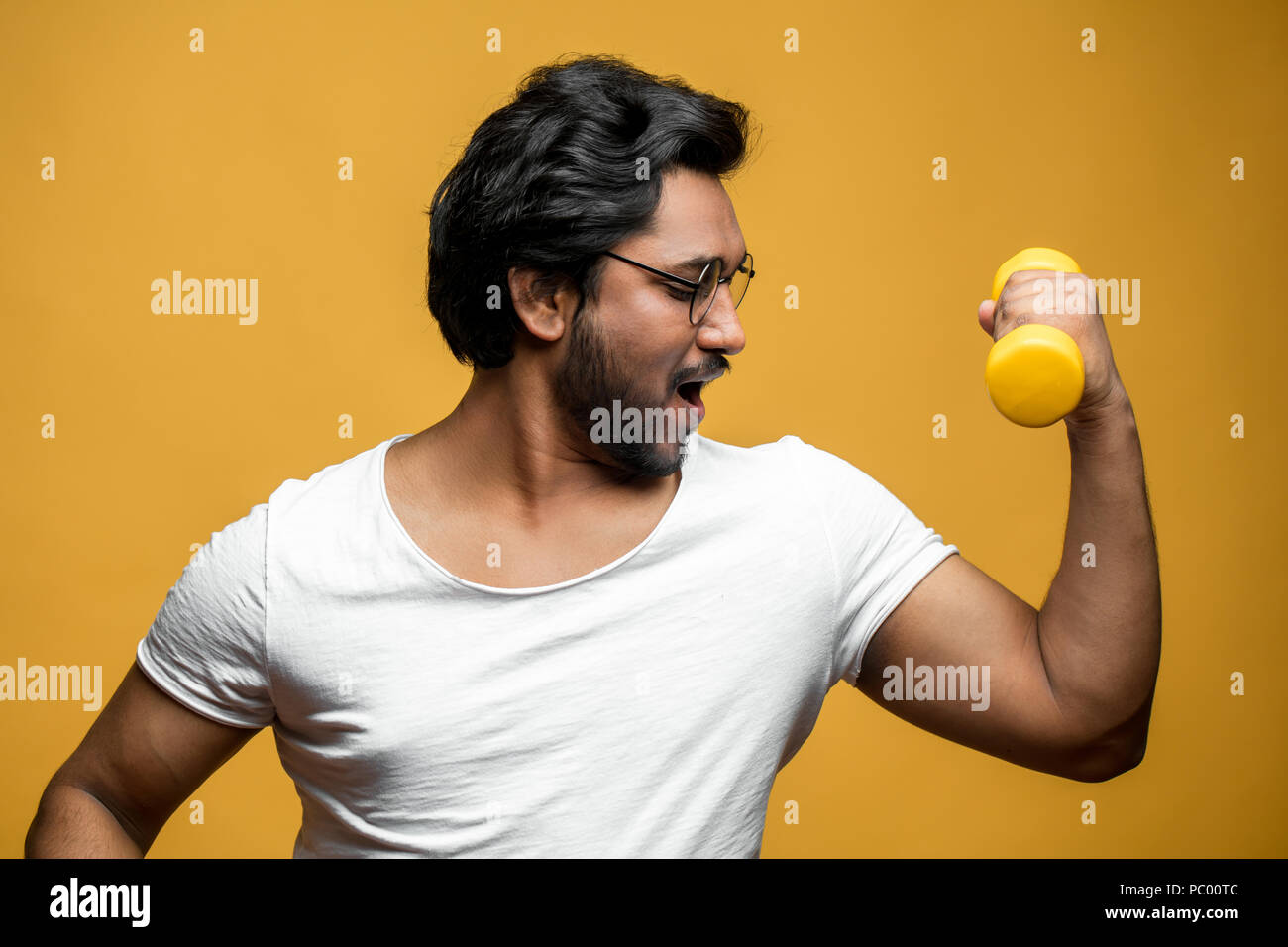 close up portrait of hindu guy demonstrating his strong arms. look at ...