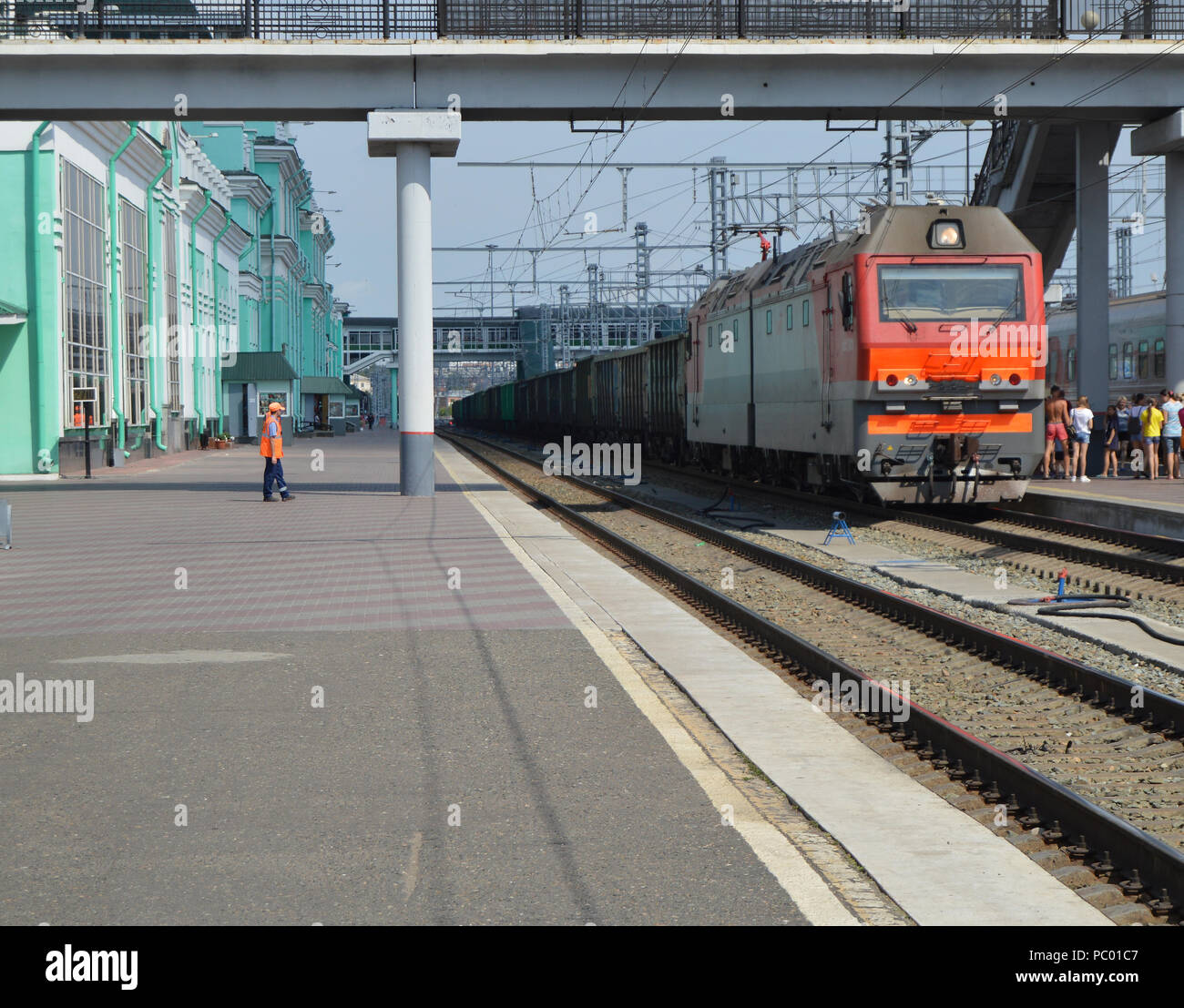 Modern locomotive carries freight train past the railway station, the ...