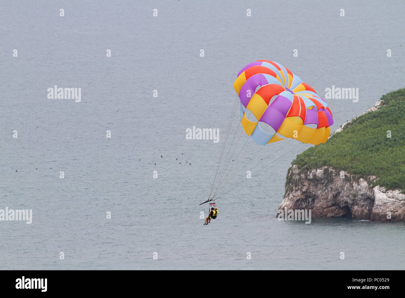 Close up of two persons on a Parasailing boat ride over the ocean going ...
