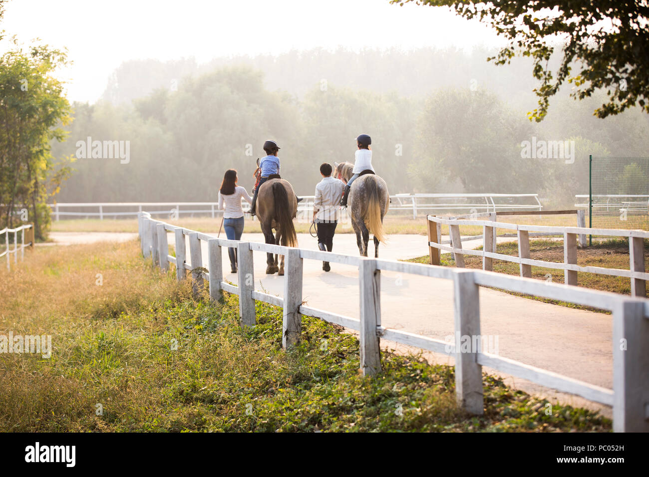 Cheerful young Chinese family riding horse Stock Photo - Alamy
