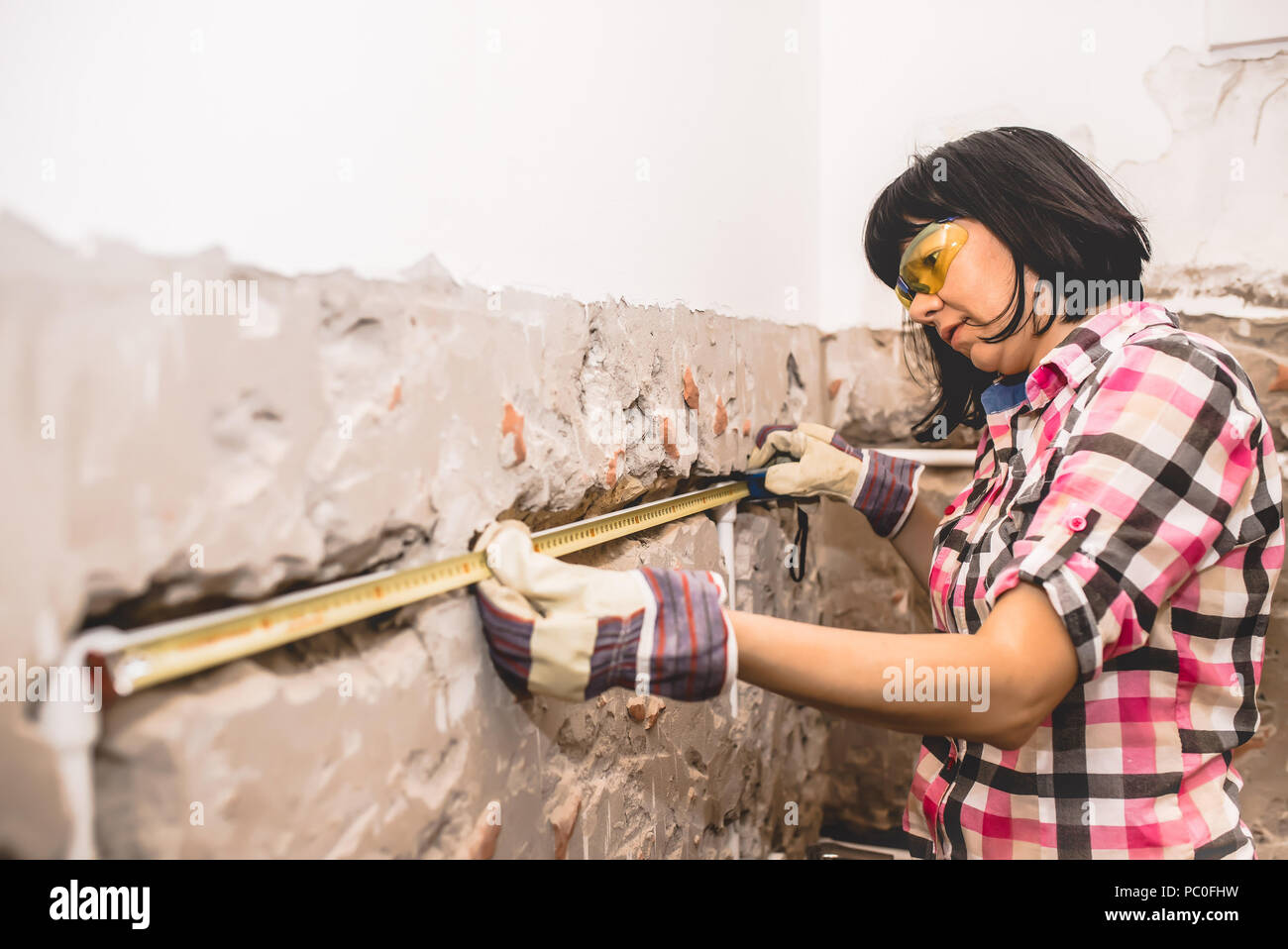 Clever woman repairing her bathroom sink pipe with positive attitude ...