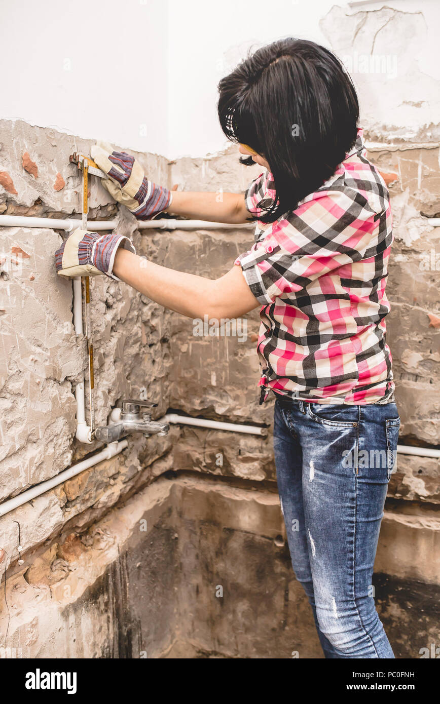 Clever woman repairing her bathroom sink pipe with positive attitude ...