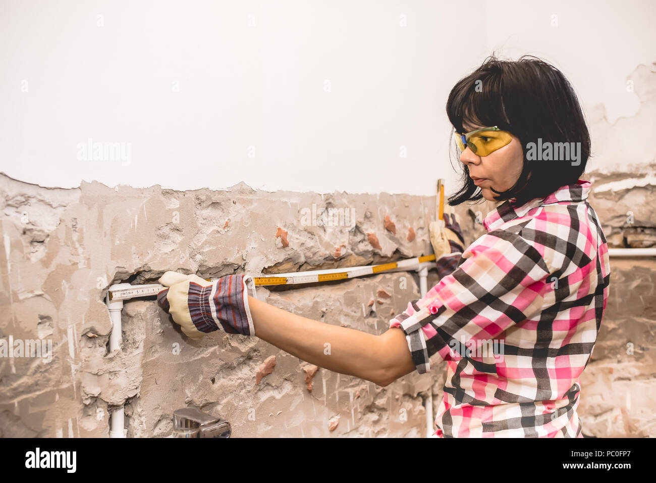 Clever woman repairing her bathroom sink pipe with positive attitude ...