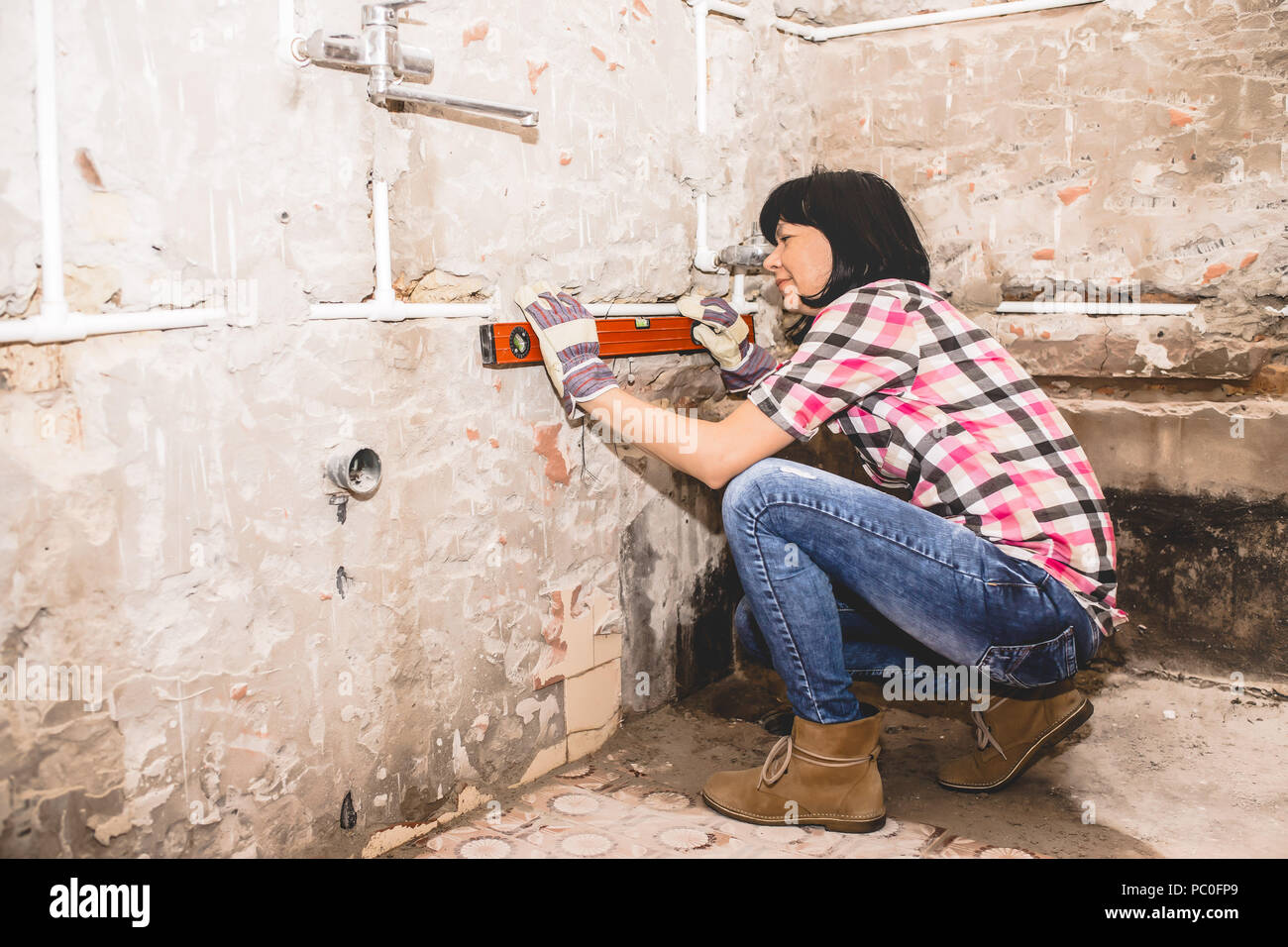 Clever woman repairing her bathroom sink pipe with positive attitude ...