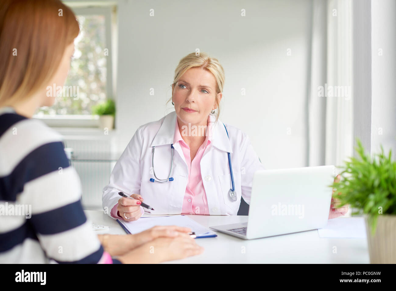Shot of female doctor talking to woman and discussing about medical ...