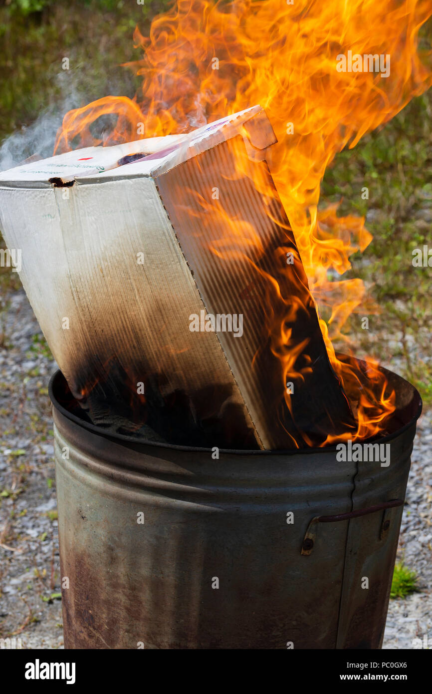 Burning waste paper and cardboard in small garden incinerator Stock ...