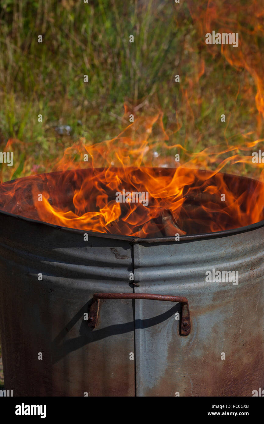 Burning waste paper and cardboard in small garden incinerator Stock ...