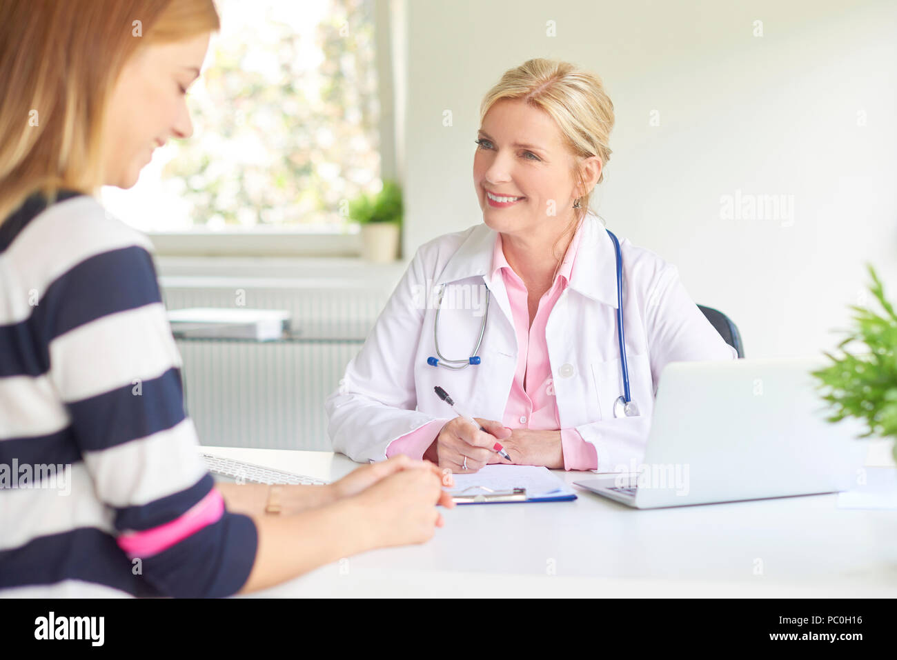 Shot of female doctor talking to woman and discussing about medical ...