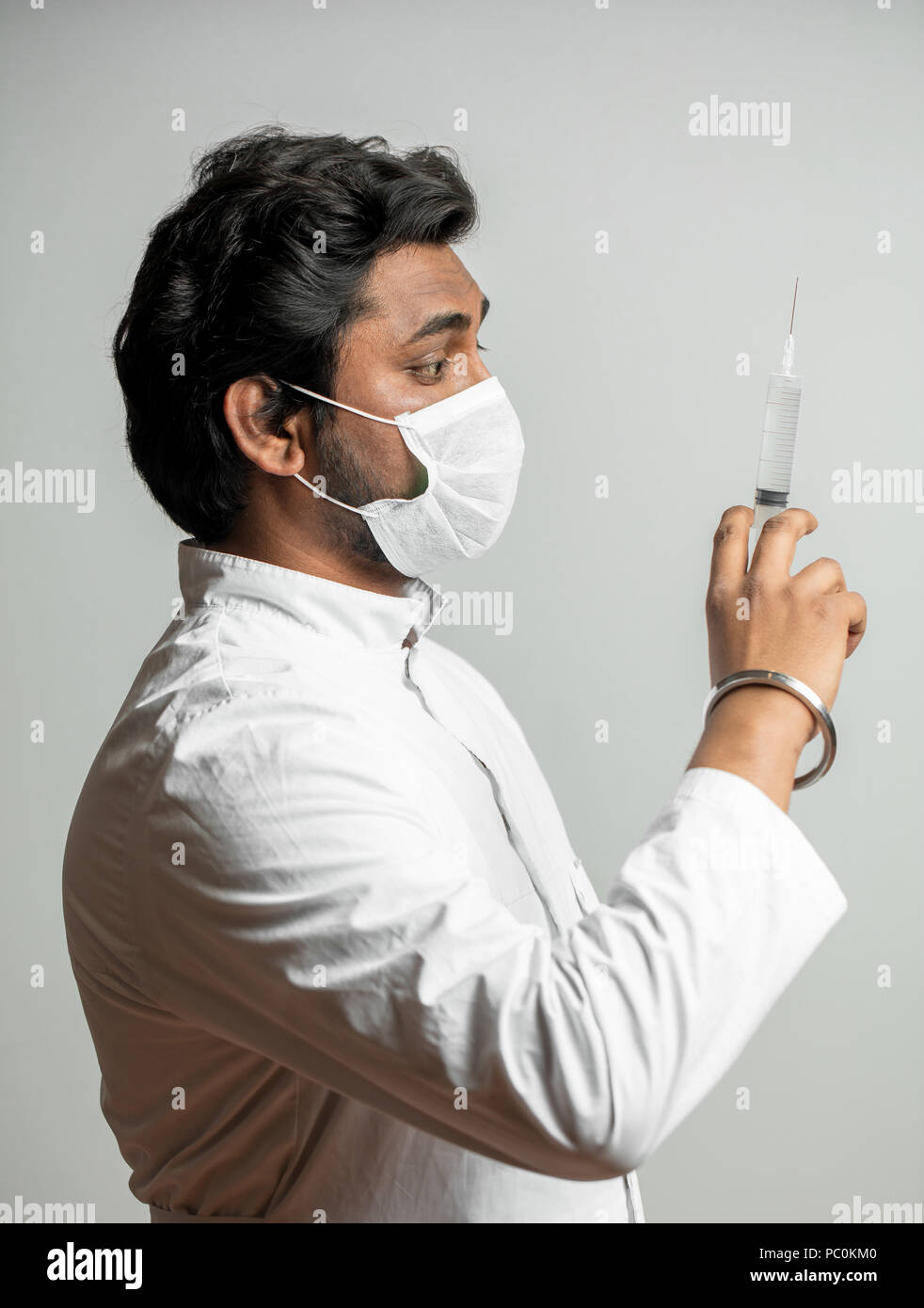 close up side view sportrait of indian doctor with syringe is preparing ...