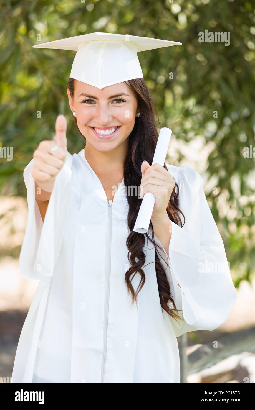 Mixed Race Thumbs Up Girl Celebrating Graduation Outside In Cap and ...