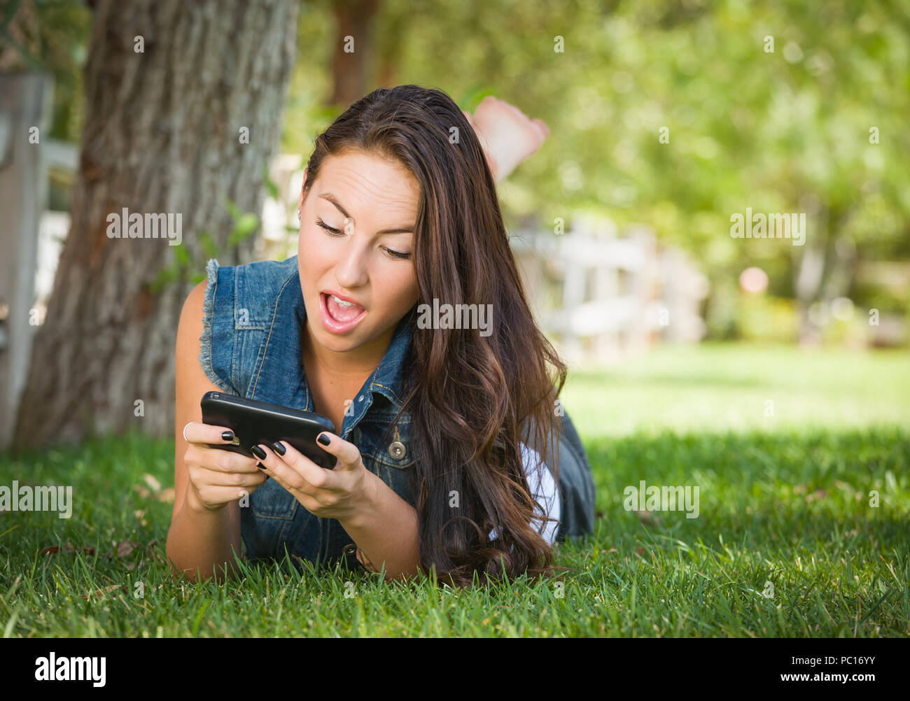 Shocked Mixed Race Young Female Texting on Her Cell Phone Outside ...