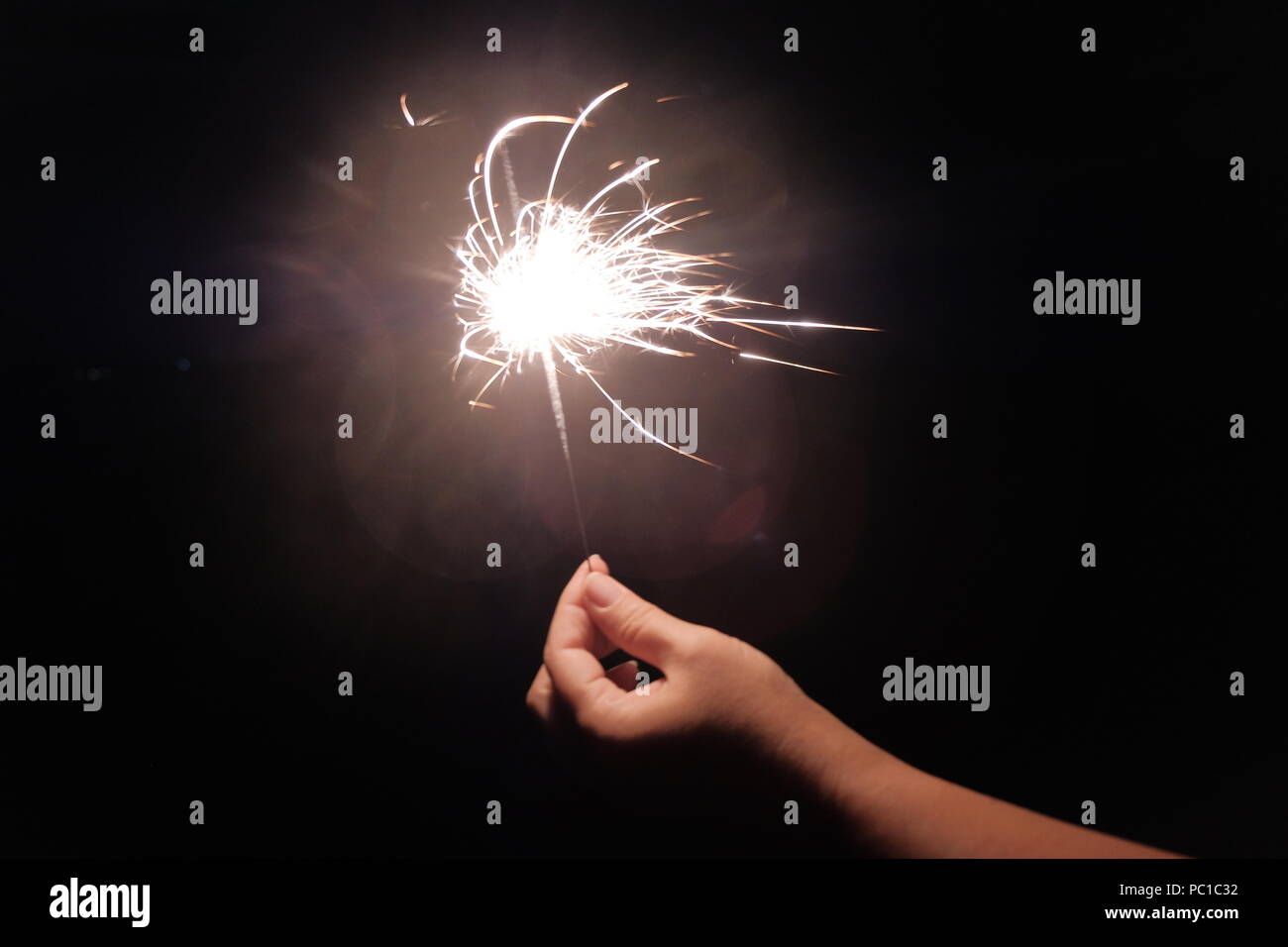 Female hand holding a burning sparkler Stock Photo - Alamy