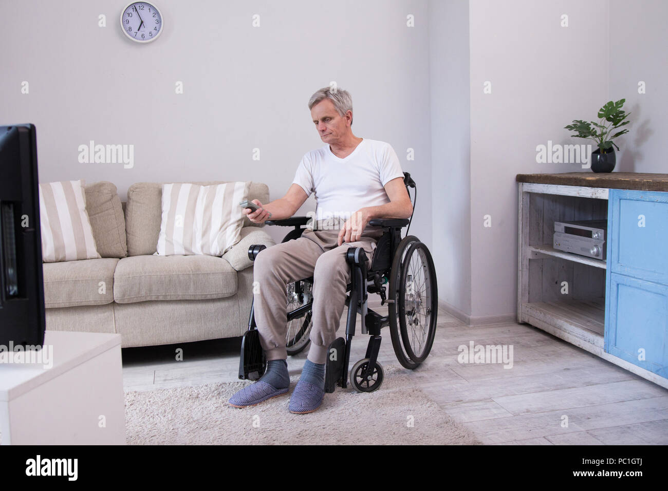 Disabled man watching television Stock Photo - Alamy