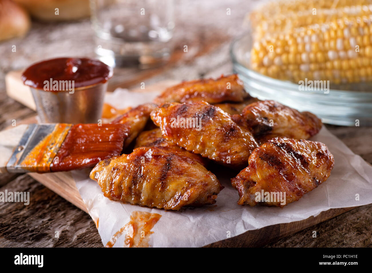 Delicious barbecue grilled chicken wings with sauce and corn on the cob ...