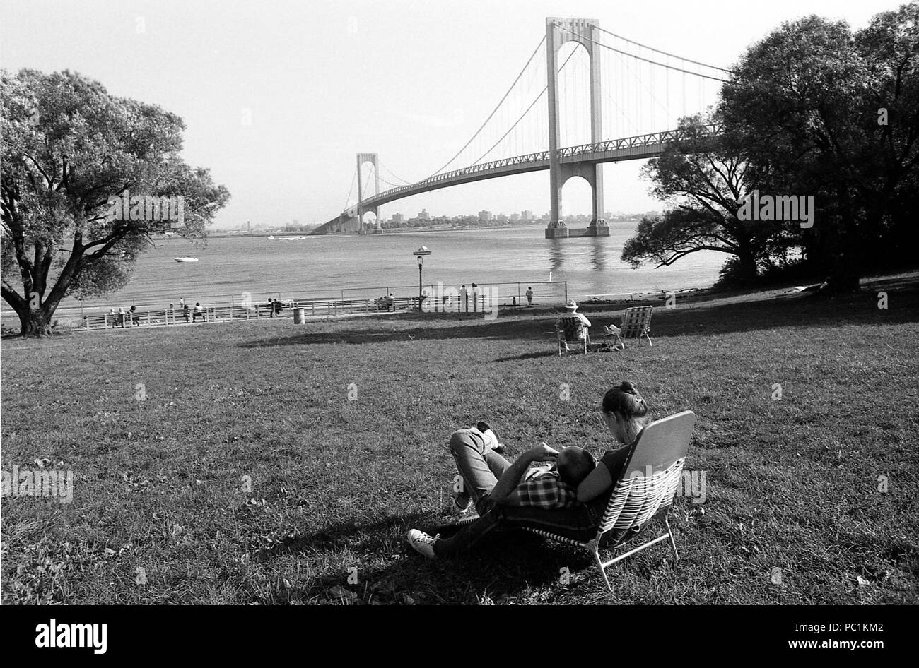 New York City, NY, USA, 1982. People relaxing in park by Hudson River ...