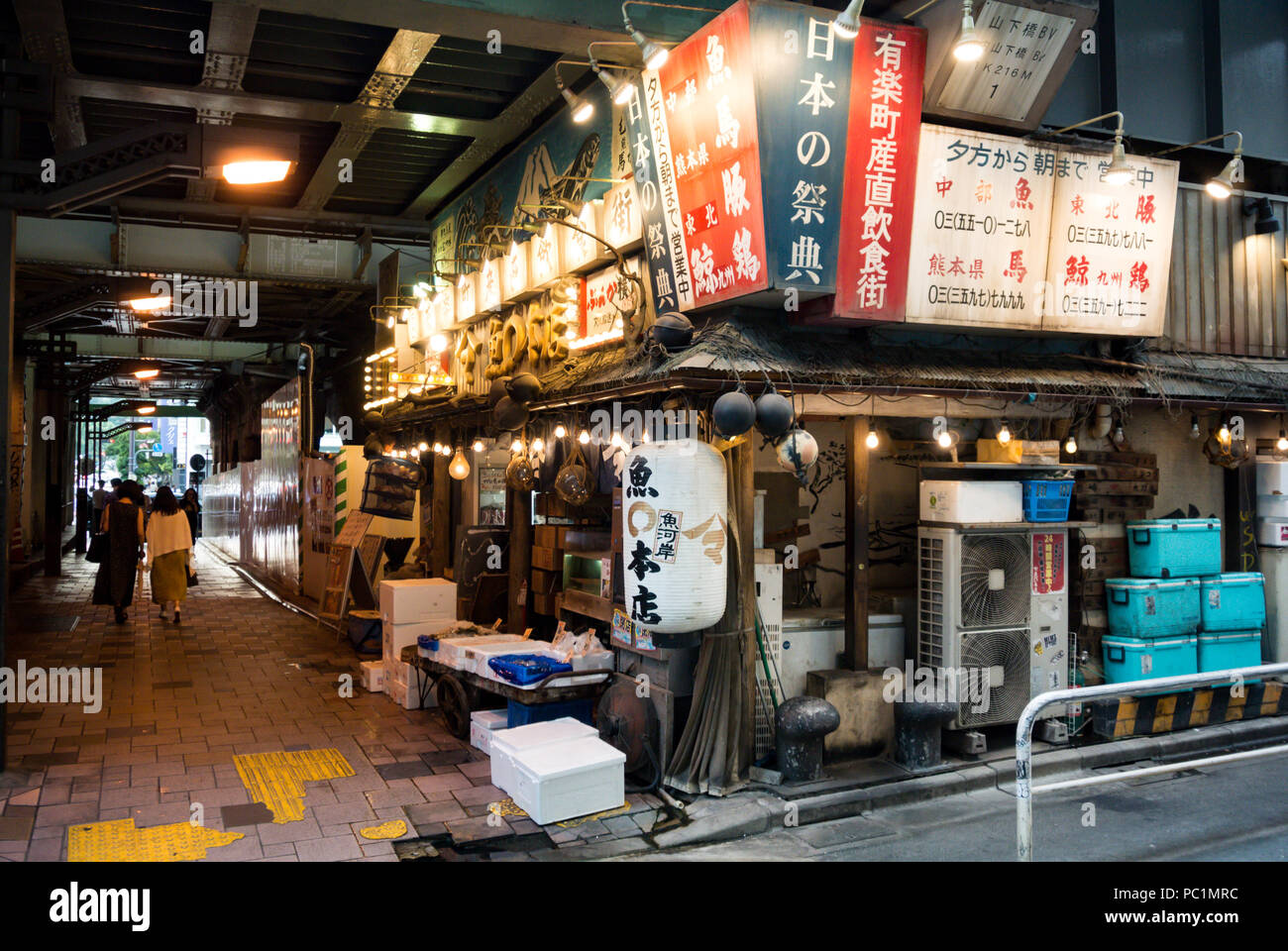 seafood restaurant under overhead railway, tokyo, japan Stock Photo - Alamy