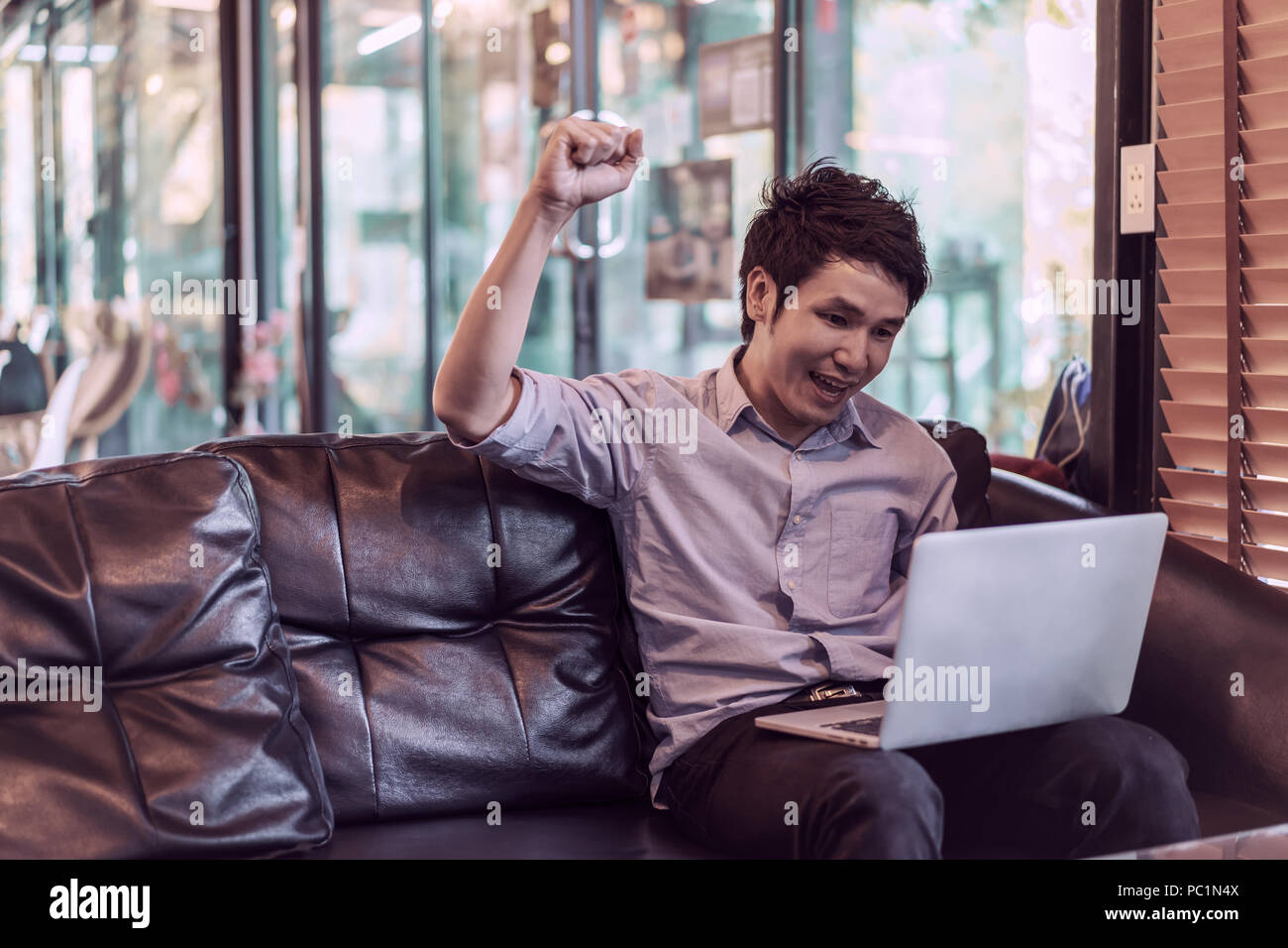 Man celebrating using laptop in hi-res stock photography and images - Alamy