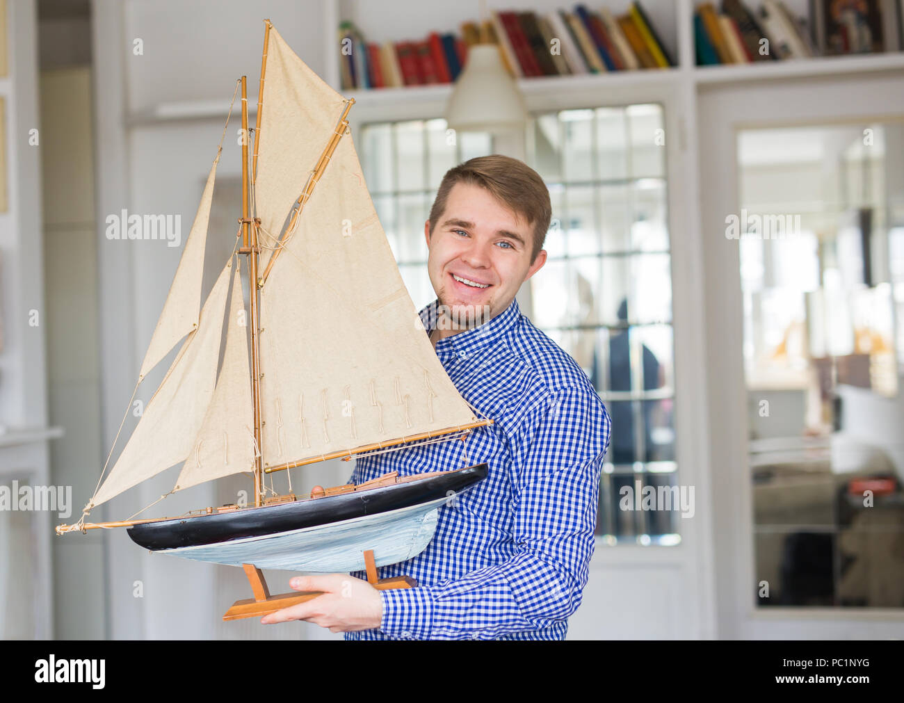 Hobby, collecting, ship and people concept - handsome man holding ...
