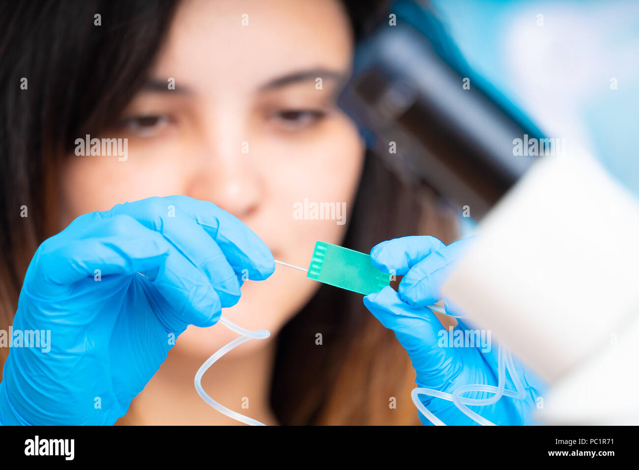 technician girl with microfluidic device LOC in microbiological lab ...