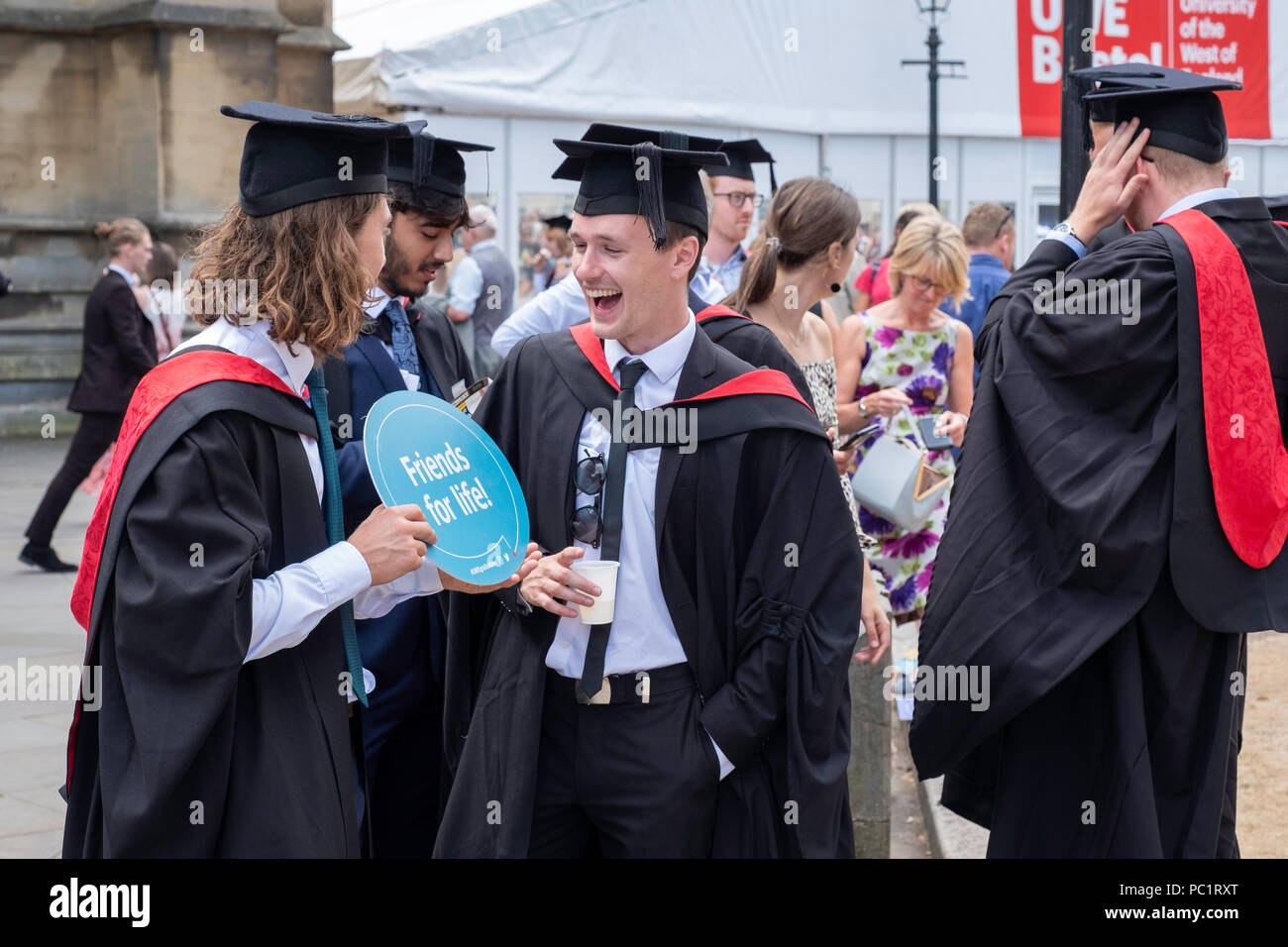 Crowd of young men celebrating graduation holding sign,"Friends for ...