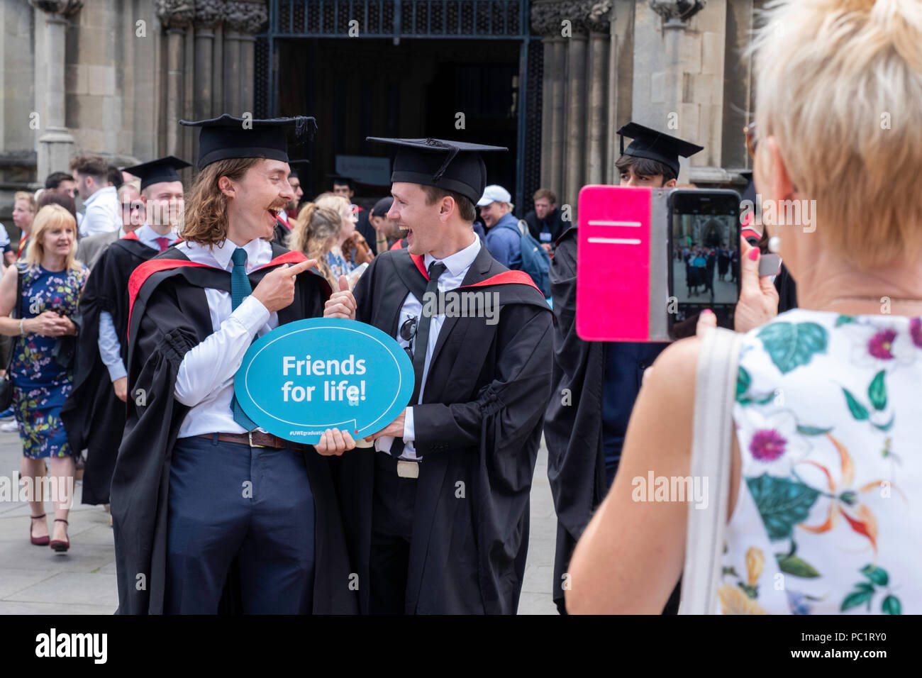 Crowd of young men celebrating graduation holding sign,"Friends for ...