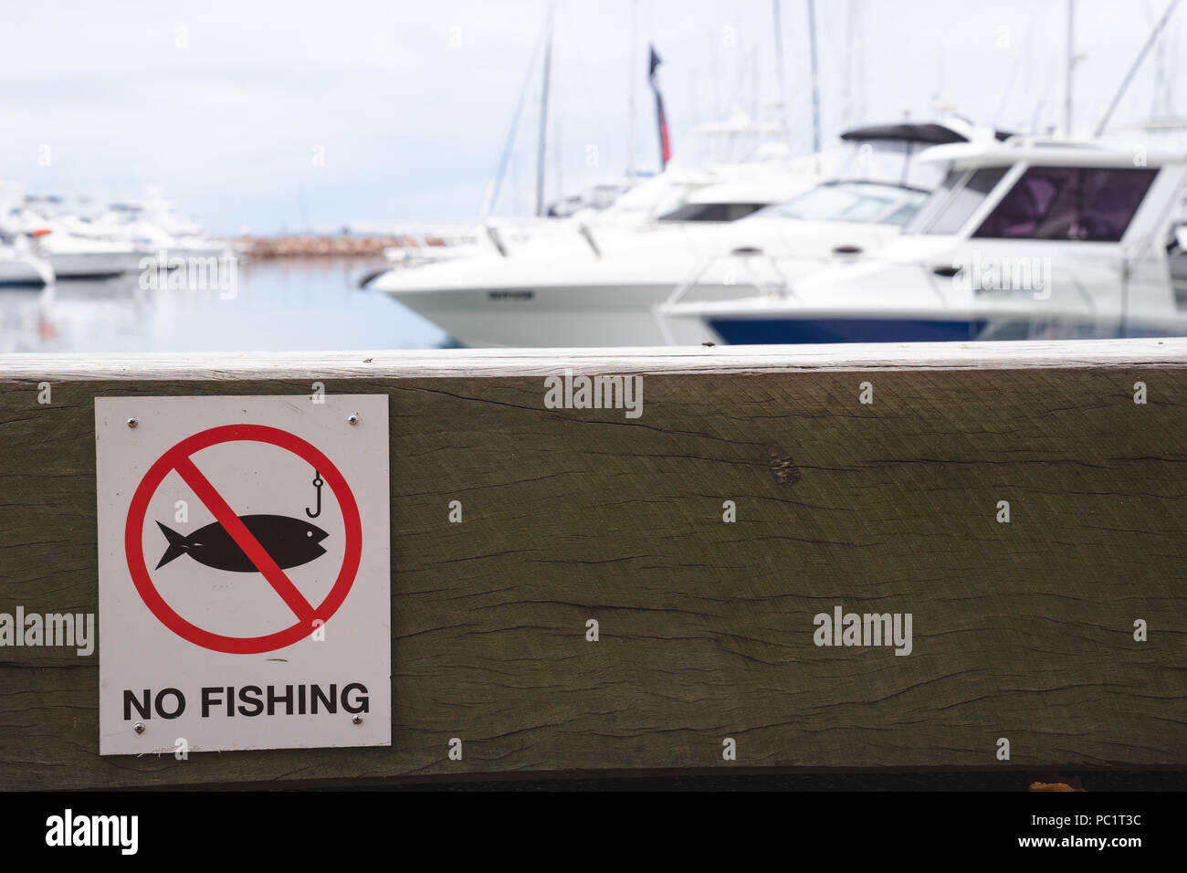 No fishing warning sign on wooden bench block for sitting in pier with ...