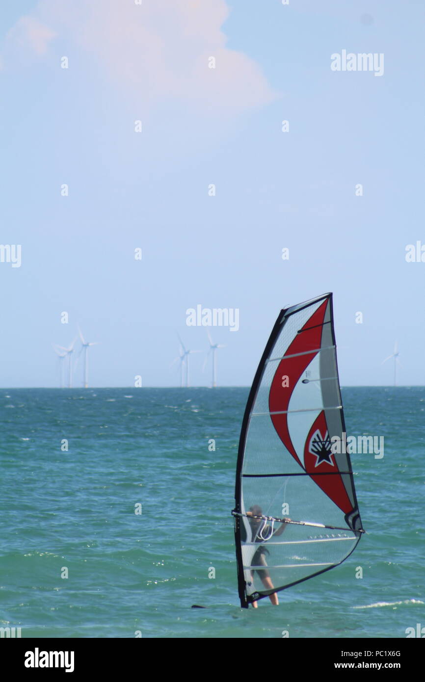 Wind surfer off Goring-by sea with wind turbines in the background ...