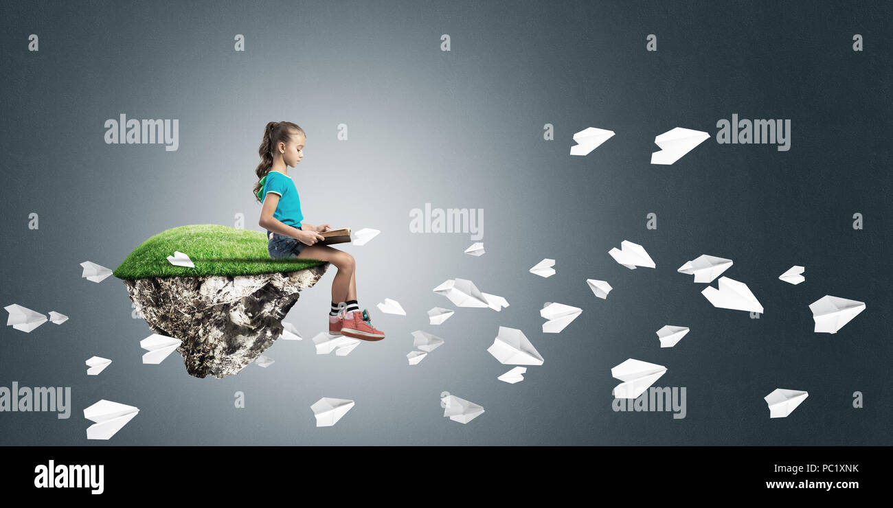 Concept of careless happy childhood with girl reading book Stock Photo ...