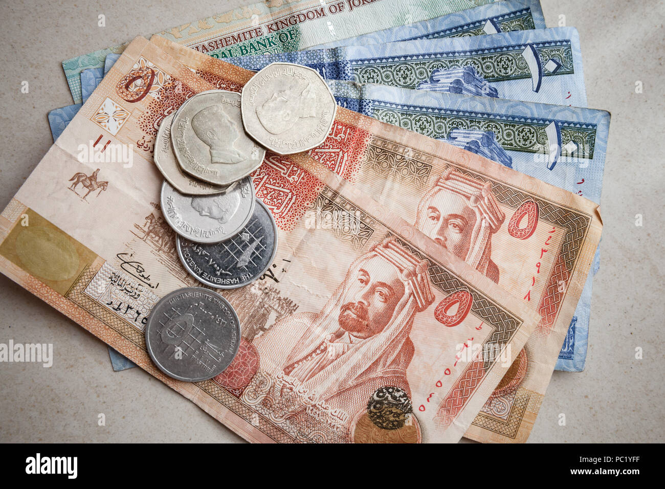 Jordanian dinars and piastres lay on gray paper background, close-up ...