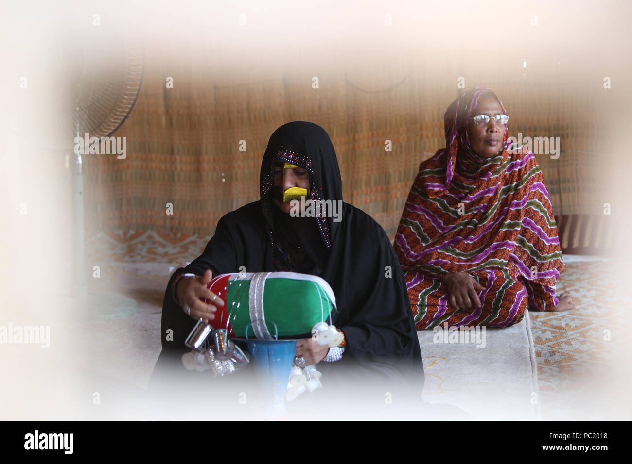 A woman sporting a metallic burqa knits Emirati flag in the heritage ...