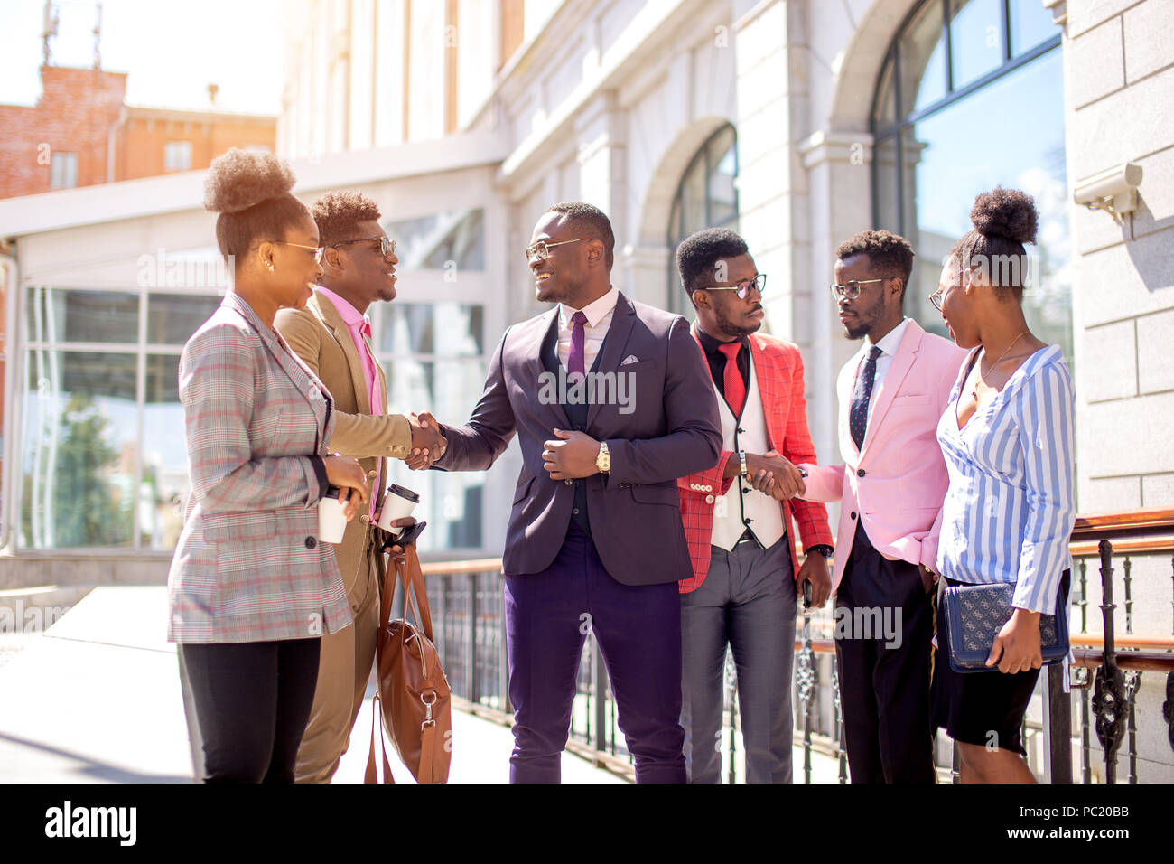 stylish boss is meeting foreign guests in front of his company. office ...