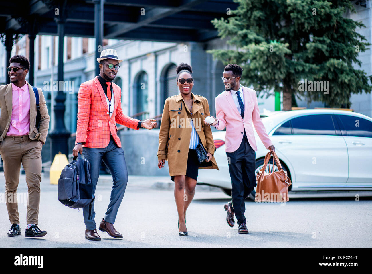 three guys are helping awesome stylish woman to carry her bags in the ...