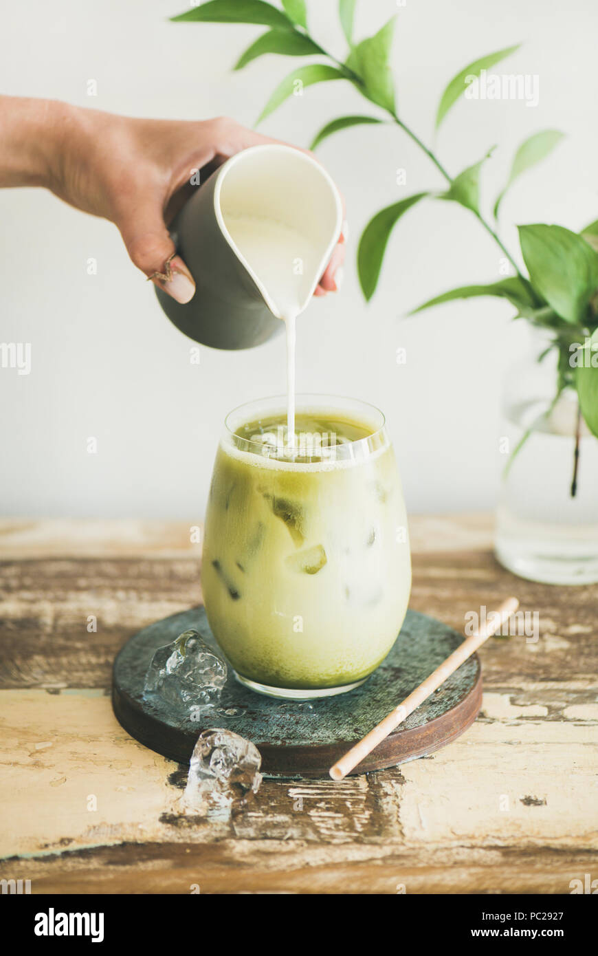 Iced matcha latte drink with milk pouring from pitcher Stock Photo - Alamy