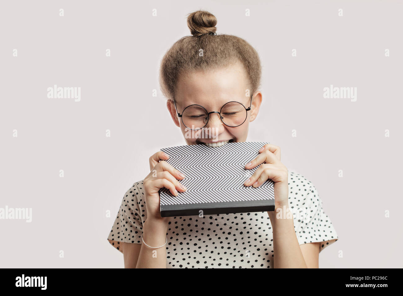 pleasant model hitting the book. bite book. angry pupil with book in teeth Stock Photo - Alamy