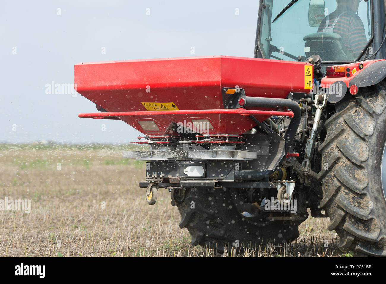 Tractor and fertilizer spreader in field Stock Photo - Alamy