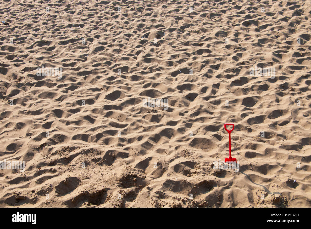 Beach life with red spade Stock Photo - Alamy