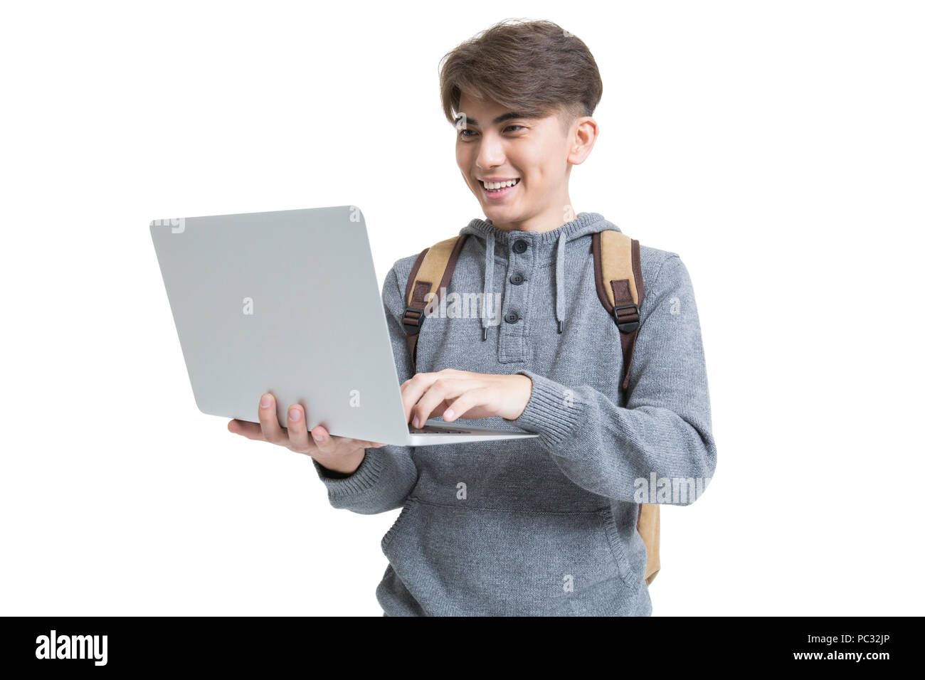 Cheerful male college student using laptop Stock Photo - Alamy