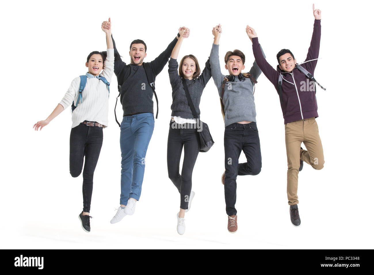 Cheerful abroad students holding hands jumping Stock Photo - Alamy