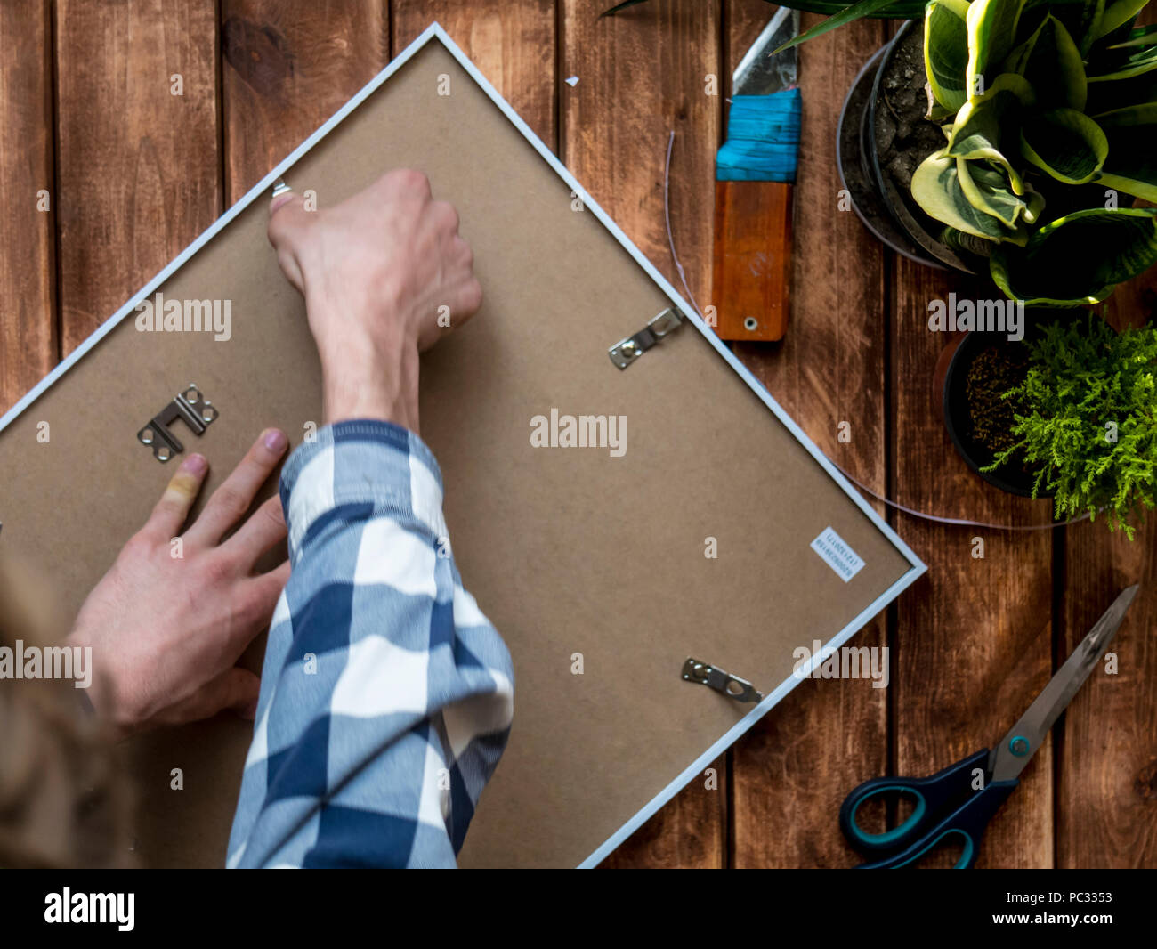 overhead man putting a photo in a wooden frame Stock Photo - Alamy