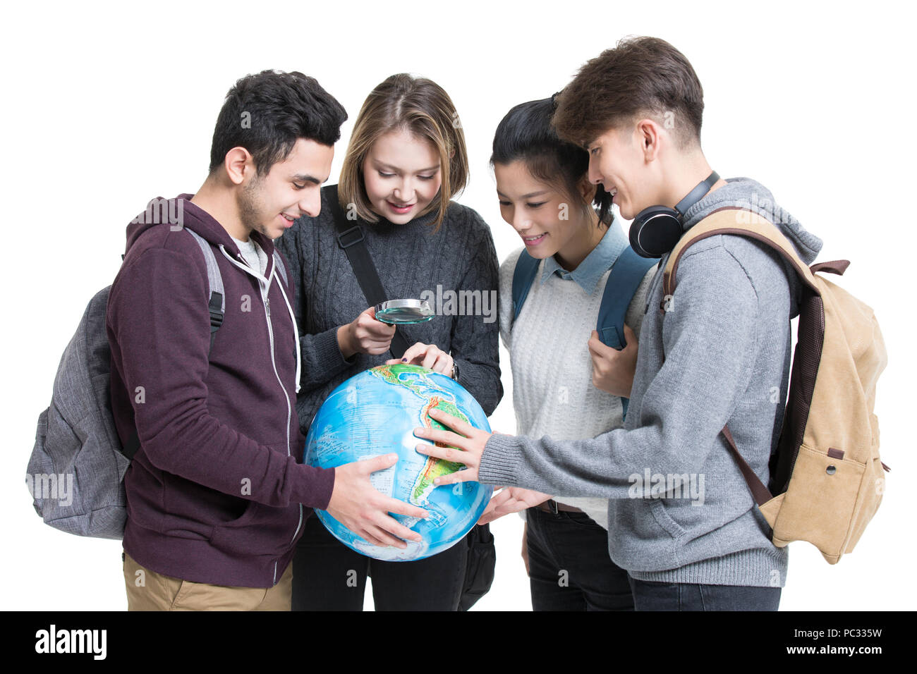 Cheerful abroad students looking at globe with magnifying glass Stock ...