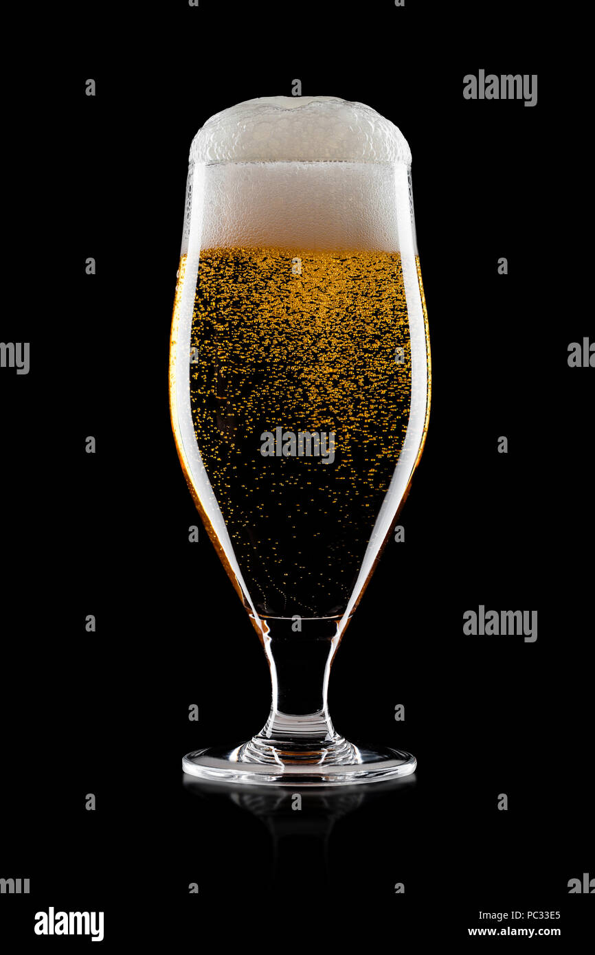 Cold glass of lager ale craft beer with foam and bubbles on black ...